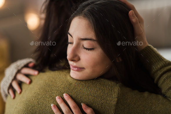 Teenage girl hugging her mother at home. Stock Photo by halfpoint ...