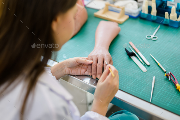 Technician making and checking prosthetic limb at prosthetic workshop ...
