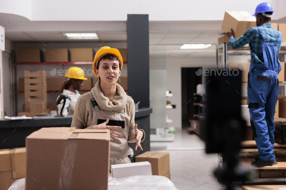 Storehouse worker recording smartphone video with inventory management ...
