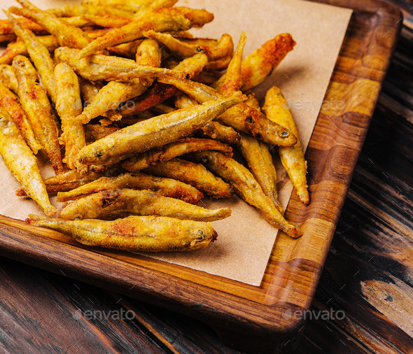 Dried small salted fish heap on crumpled paper Stock Photo by AntAlexStudio