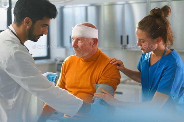 Young doctor and nurse treating injury of senior man. Stock Photo by ...