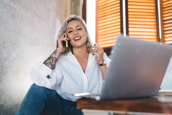 Cheerful female millennial with laptop computer posing while making ...