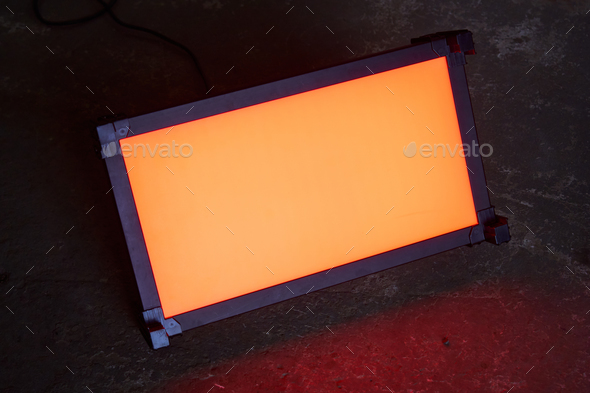 lighting LED panel stands on the floor and shines with orange light ...