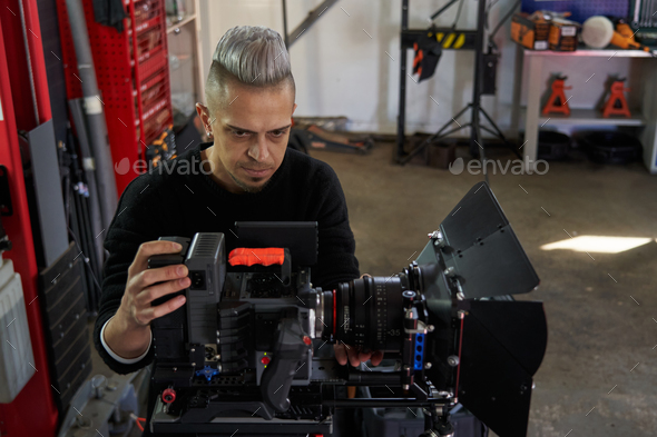 caucasian man cameraman monitors the process of filming with a ...
