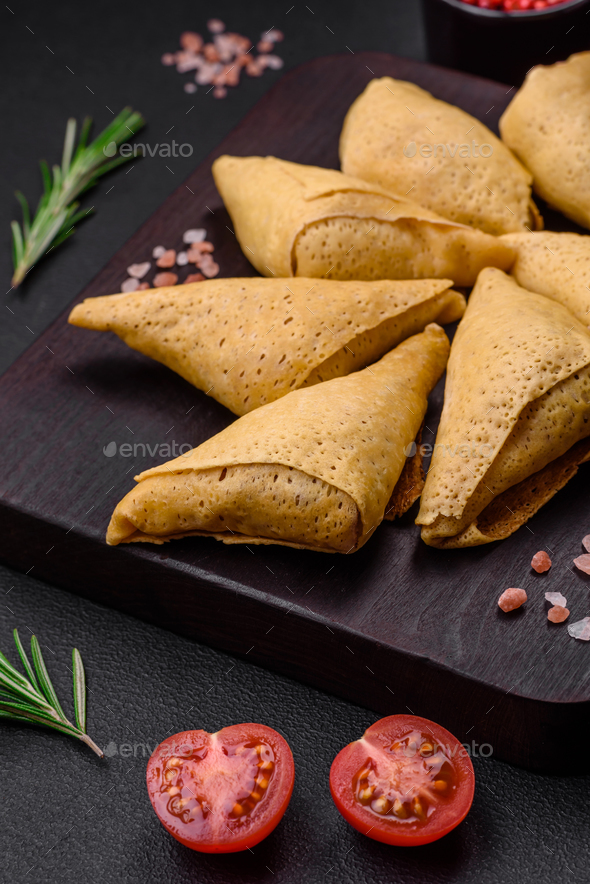 Delicious pancakes triangular shape with meat, salt and spices Stock ...