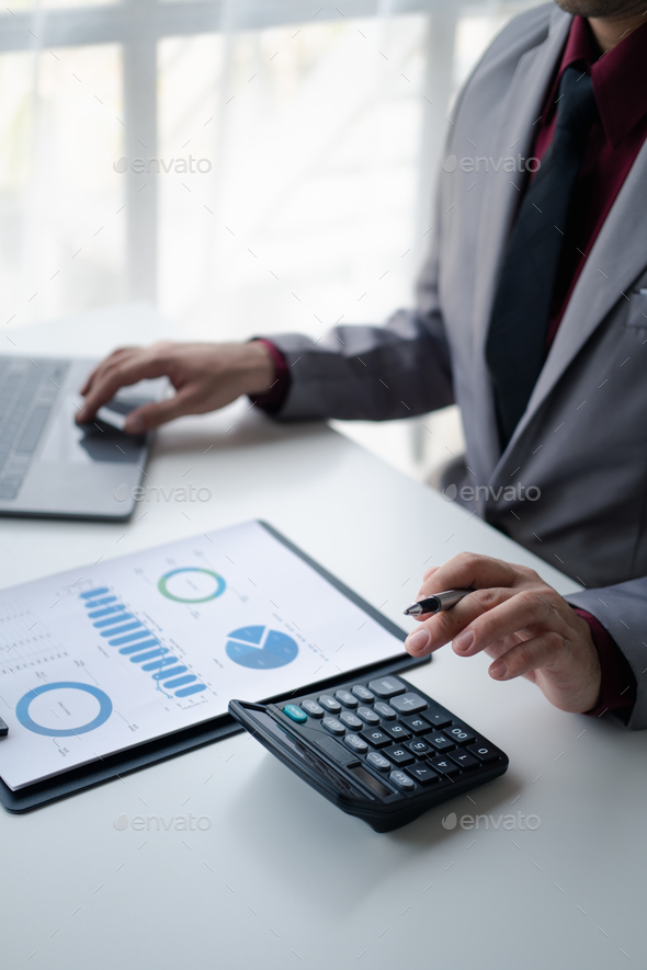 Close up view of Businessman using a calculator to calculate financial ...