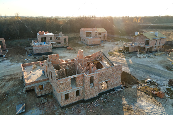 Aerial view of new homes with brick framework walls under construction ...