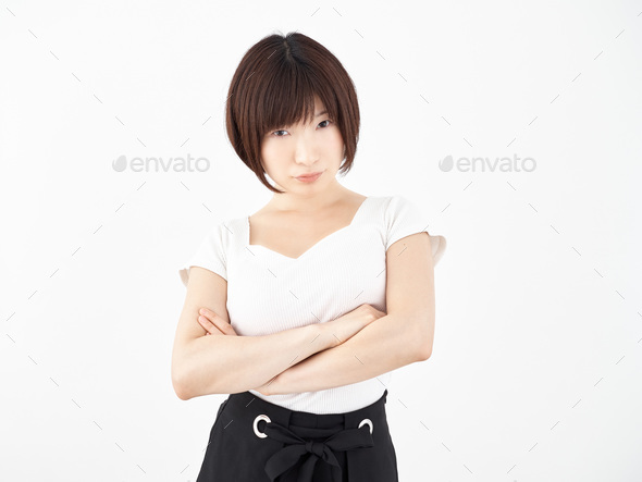 An angry woman with arms folded against a white background Stock Photo ...