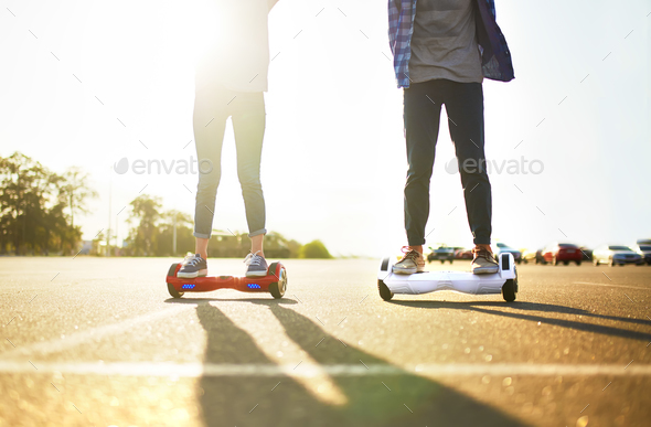 Legs of man and woman riding on the Hoverboard together outdoor. Active ...