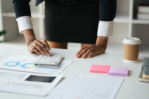 Close up view of accountant using calculator to analyze her ...