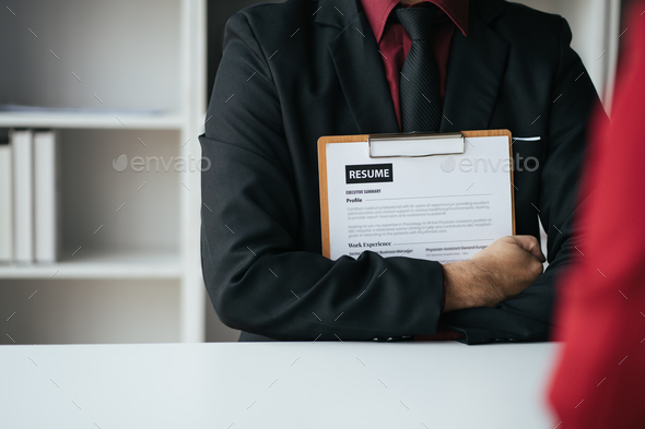 Close up view of applicant presenting his resume to the employer during ...