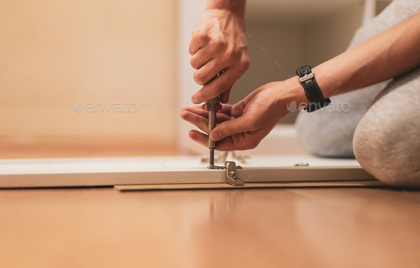 The hands of a young man are twisting a screw with a screwdriver. Stock ...