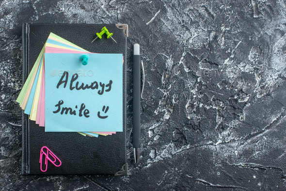 top view always smile note with black copybook on gray background ...