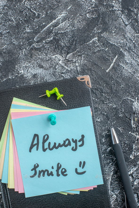 top view always smile note with black copybook on gray background ...