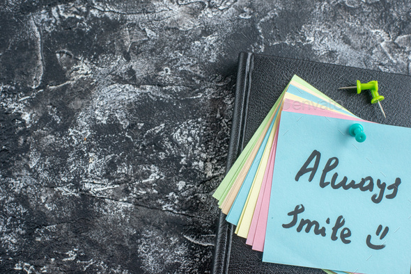 top view always smile note with black copybook on gray background ...