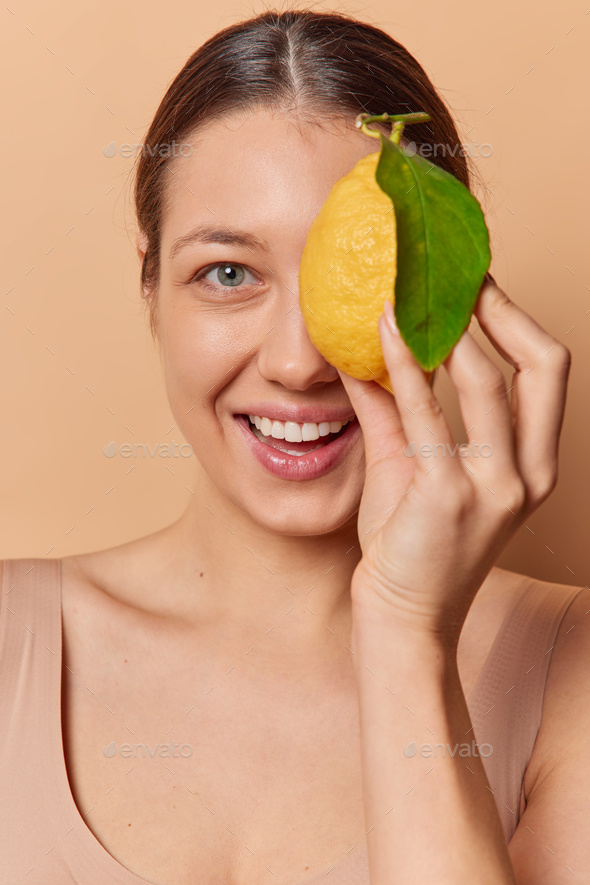 Natural beauty concept. Positive dark haired woman covers face with ...
