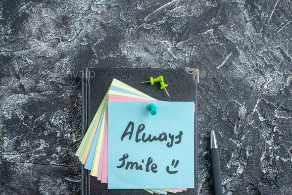 top view always smile note with black copybook on gray background ...