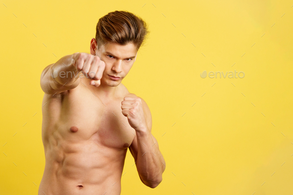 Strong shirtless man doing shadow boxing while looking at camera Stock ...