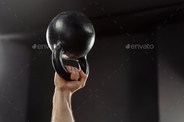 Muscular hand holding heavy kettlebell on gym background Stock Photo by ...