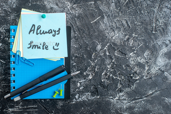 top view always smile note with pens and copybook on gray background ...