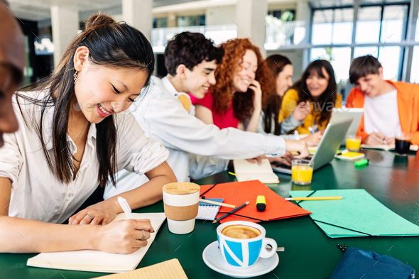 Young multiracial college students studying together at campus ...