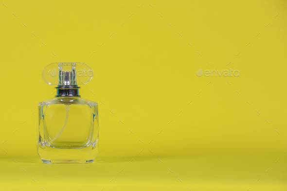 perfume bottle laid on a yellow background with copy space for design ...