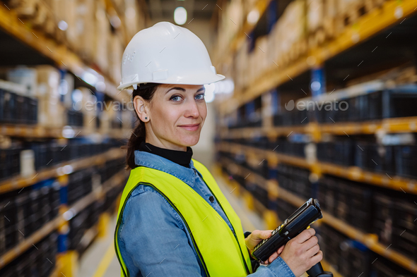 Warehouse female worker checking up stuff in a warehouse. Stock Photo ...