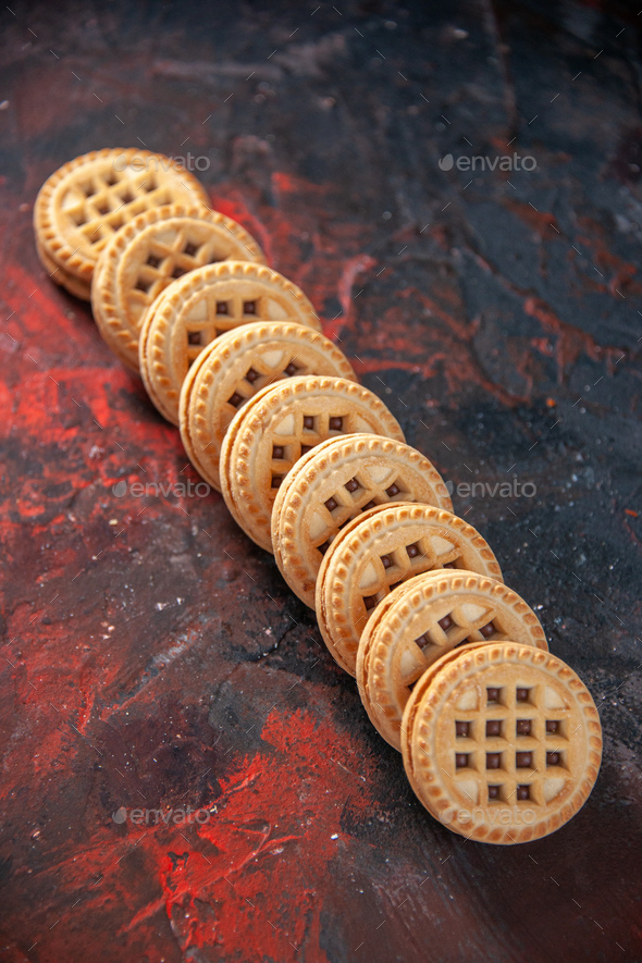 Overhead view of tasty sugar cookies laid side by side on mix colors ...