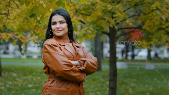 Beautiful young elegant woman looking into distance crossed arms over ...