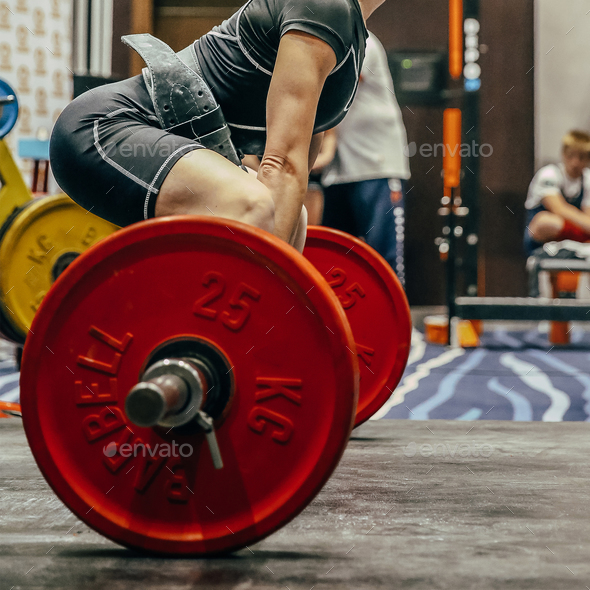 side view female athlete perform deadlift in powerlifting competition ...