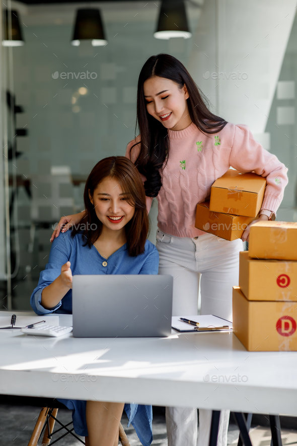 Two Young Asian women are happy and excited after a new order from SME ...