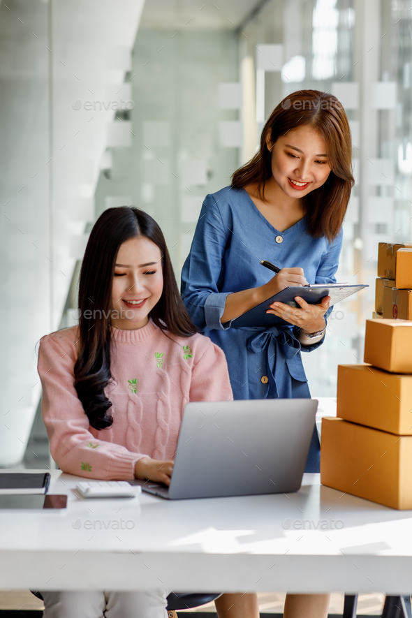Two Young Asian women are happy and excited after a new order from SME ...