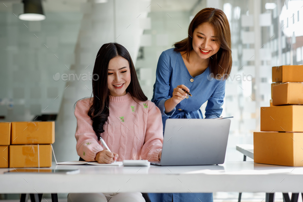 Two Young Asian women are happy and excited after a new order from SME ...