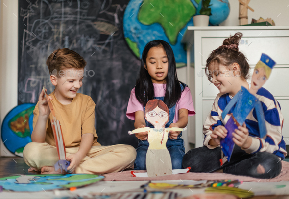 Little children playing with a handmade puppets. Stock Photo by halfpoint