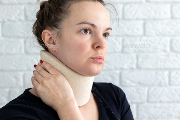 Unhappy woman with cervical surgical collar feeling pain in neck Stock ...