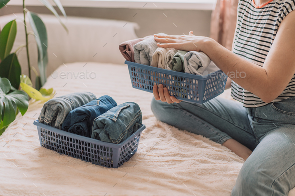 Lady organized her clothes into blue containers Stock Photo by Nestea06