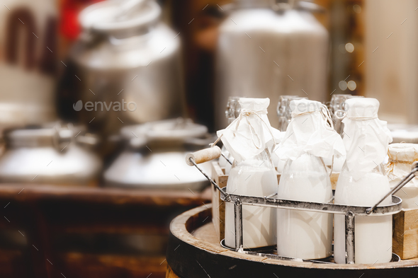Glass bottles with fresh natural milk, aluminum cans on hay on dairy ...