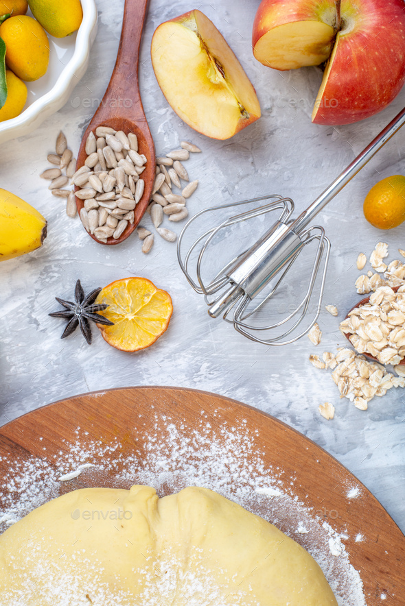 Top view of raw pastry on round board fresh fruits oatmeal on ice ...