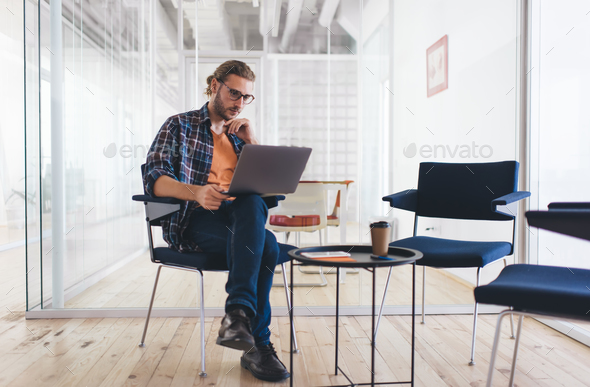 Skilled employee watching video webinar in social media using laptop ...
