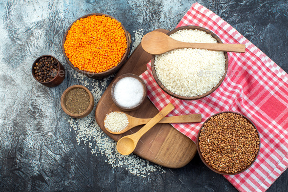 top view raw rice with orange lentils and buckwheat on dark background ...