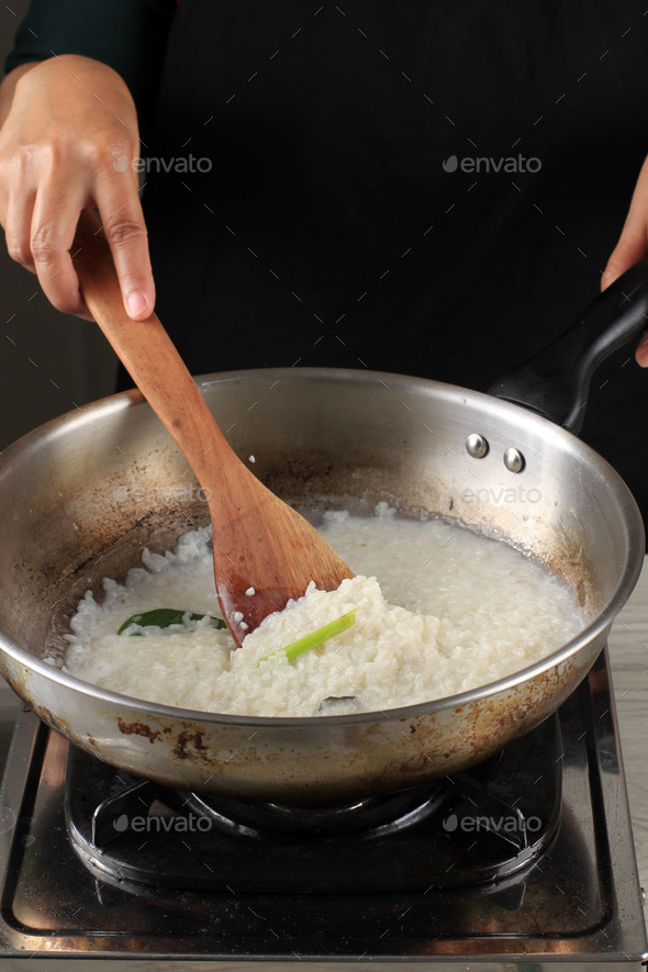 Asian Women Boiled Sticky Rice on A Pan in the Kitchen. Stir Sticky ...