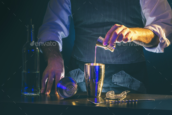Bartender pouring cocktail ingredients in shaker Stock Photo by vladans