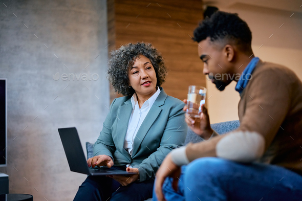 Insurance agent and her client using laptop during a meeting in the ...