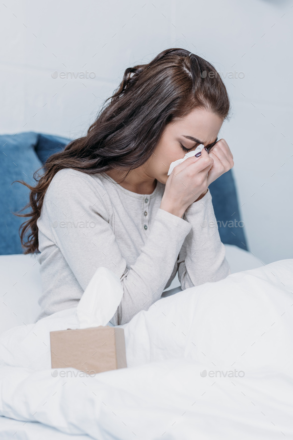 woman lying in bed with tissue box, crying and wiping tears Stock Photo ...