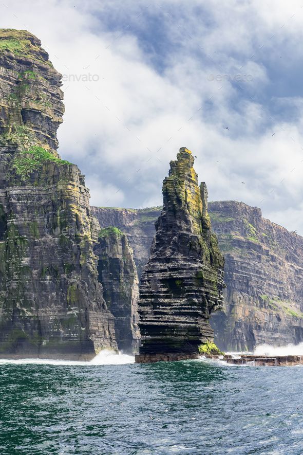 Vertical of the Cliffs of Moher under a cloudy blue sky Stock Photo by ...