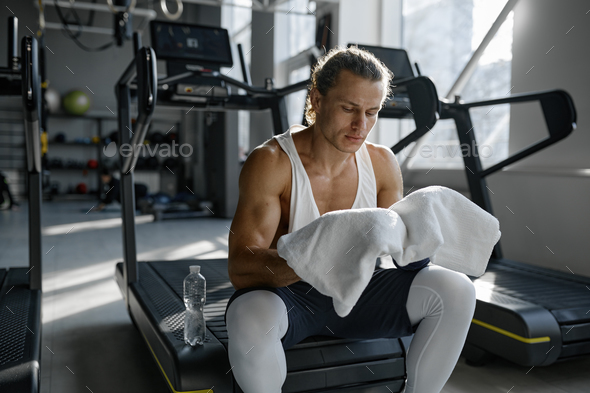 Sportsman with muscular body feeling exhausted after treadmill training ...