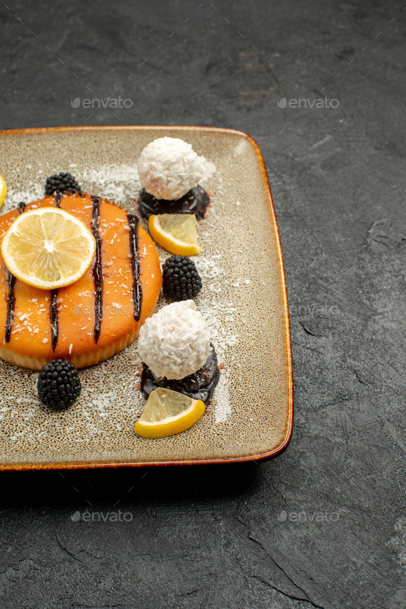 front view yummy cake dessert with lemon slices and coconut candies on ...