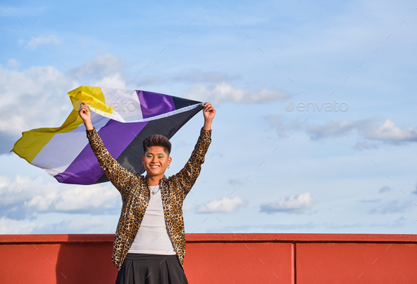 gender non binary asian person smiling holding gender non binary flag ...