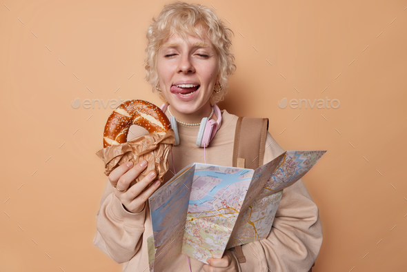 Satisfied female tourist discovers new city and eats traditional food ...