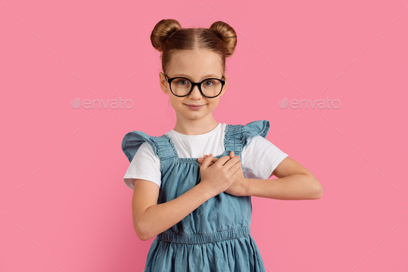Gratitude Concept. Portrait of cute little girl keeping hands on chest ...